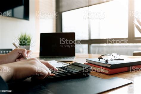 계산기에서 작업하는 사업가 또는 회계사 손 잡고 펜을 닫아 사무실 비즈니스 개념에서 비즈니스 데이터 회계 문서 및 랩톱 컴퓨터를 계산합니다 개념에 대한 스톡 사진 및 기타
