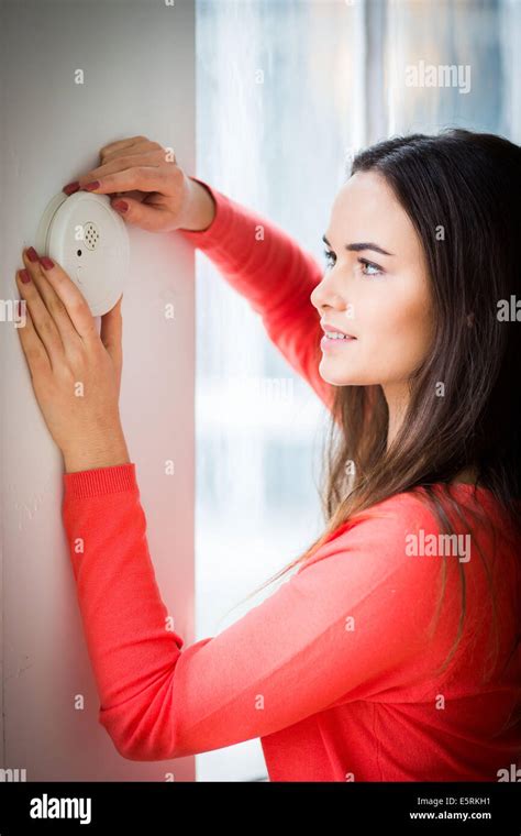 Woman Installing A Smoke Detector Stock Photo Alamy
