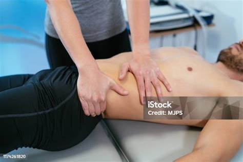 Closeup To The Hands Of A Physiotherapist Massaging The Ribs Of A Lying