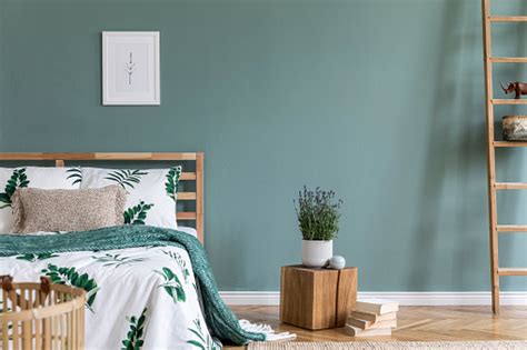 나무 침대 포스터 프레임 큐브 사다리 식물 책과 우아한 액세서리를 조롱 침실 인테리어의 세련되고 디자인 구성 아름다운 침대 시트