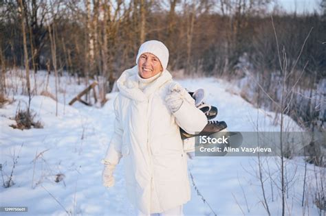 화창한 눈 덮인 겨울 야외에서 아이스 스케이트를 입고 노는 흰색 따뜻한 아웃웨어를 입은 행복한 노인 성숙한 여성 은퇴 한 건강한 사람들 휴가 겨울 활동 활동적인 라이프
