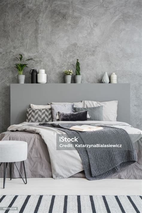편안한 침대 린 넨 베개 담요와 회색 스타일 침실 인테리어에 그것을 열려 있는 책의 전면 모습 녹색 식물과 장식 화병입니다 실제 사진 침구에 대한 스톡 사진 및 기타 이미지
