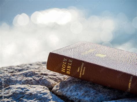 Close Up Holy Bible On Stone With Bokeh Morning Light Blue Sea As