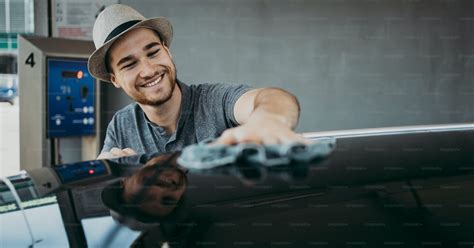 걸레 자동차 디테일링또는 발렛 개념으로 자동차를 청소하는 모자를 쓴 젊은 잘생긴 남자 사진 Unsplash의 사진술 이미지