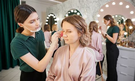 Makeup Artist Applying Makeup On Female Client In Beauty Salon Stock