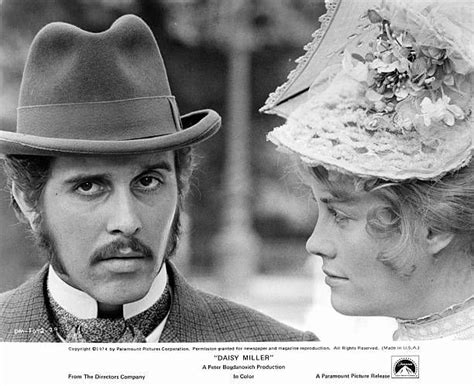 An Old Photo Of Two People With Hats On Their Heads And One Is Looking At The Other