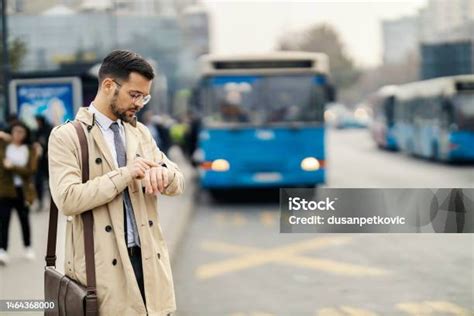 세련된 남자가 손목시계를 보고 시내에서 버스를 기다리고 있다 거리에 대한 스톡 사진 및 기타 이미지 거리 검사 보기 기업 재무와 산업 Istock