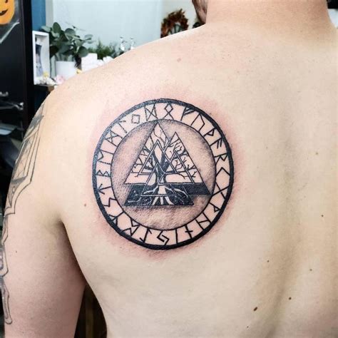 A Man With A Triangle Tattoo On His Back
