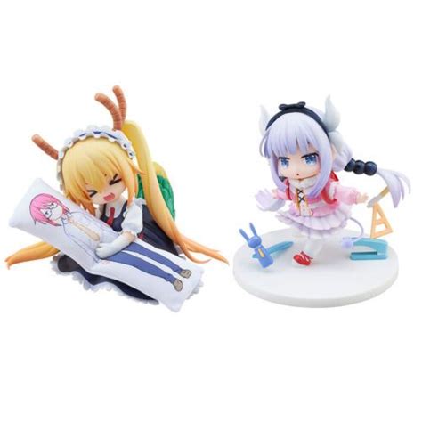 Two Anime Figurines Sitting Next To Each Other On Top Of A White Table