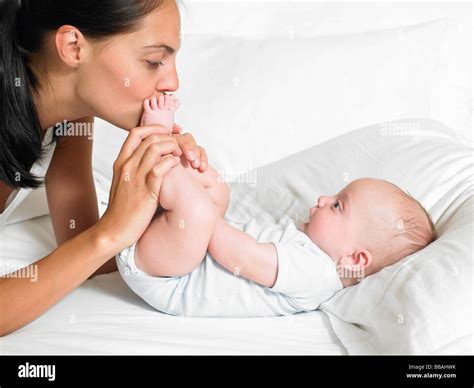 Mother Kissing Her New Born Baby S Feet Stock Photo Alamy