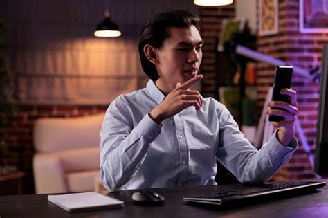 스마트 폰에서 온라인 화상 통화를 사용하는 사무실 근로자 Brand Name Smart Phone에 대한 스톡 사진 및 기타