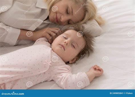 Cerrarse Encima De La Madre Serene De Disparo Durmiendo Con El Beb En La Cama Imagen De Archivo