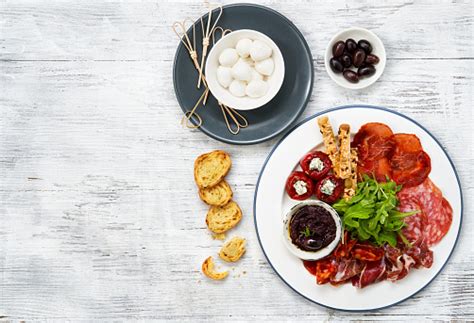 이탈리아 안티파스티 또는 스페인 타파스 파노라마 미식가 차가운 고기와 접시에 치즈로 채워진 빨간 작은 체리 고추 평면도 흰색 나무 배경 텍스트 공간을 복사합니다 0명에 대한