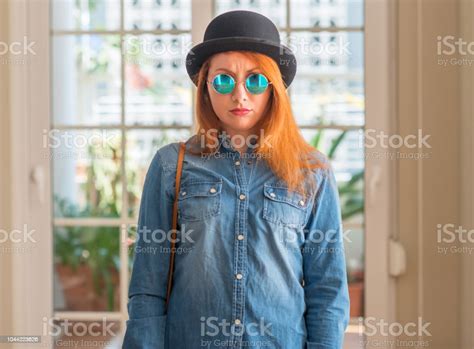 세련 된 빨간 머리 여자 문제 때문에 중산 모자와 선글라스 의심과 긴장 찡그림 화가 입고 부정적인 사람입니다 감정에 대한 스톡