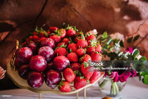 과일 딸기 자두가 든 접시 캔디 바 근접 촬영 맛있는 결혼식 피로연 호화로운 예식 배경 장식입니다 테이블은 연회에서 생일 파티를 위해 분홍색 꽃을 장식했습니다 0명에 대한