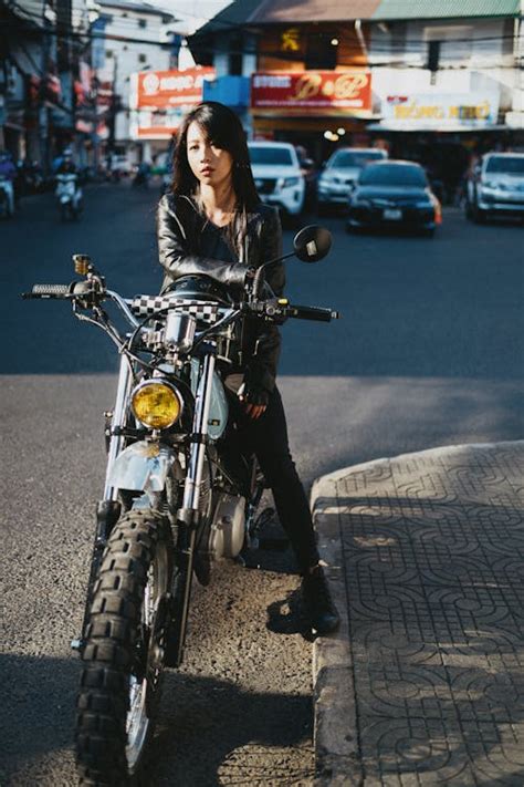 가죽 자켓 간판 거리 거리 사진 건물 검은 옷 교차로 교통 길모퉁이 노란색 헤드라이트 도시 스타일 도시 풍경 도시의 도시의 삶 도심 독립 모터