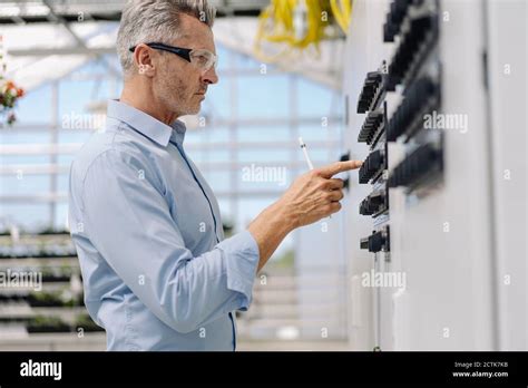 Male Professional Operating Control Panel While Standing In Greenhouse Stock Photo Alamy