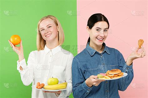 饮食。节食的概念。健康食品。美丽的年轻女人在水果和不健康的快餐之间选择