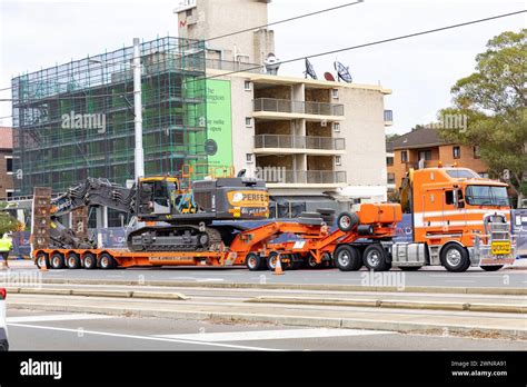 Oversize Low Loading Vehicle Transports A Construction Excavator Digger To A Building Site In