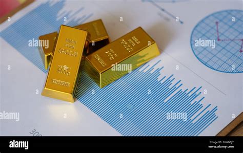 Small Gold Ingots On Financial Statistics Document With Charts And