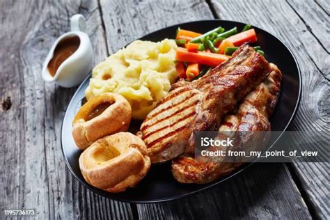 뼈에 구운 돼지 갈비 으깬 감자 녹색 콩 당근 요크셔 푸딩 양파 그레이비를 곁들인 잉글리시 선데이 로스트 0명에 대한 스톡 사진 및 기타 이미지 Istock