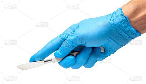 手术刀在医生手中,手套孤立在白色背景上。外科医生在手术前用刀 手术刀在医生手中,手套孤立在白色背景上。外科医生在手术前用刀
