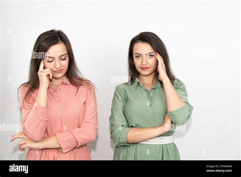 Two Caucasian Twin Models Posing Together And Thoughtful On White