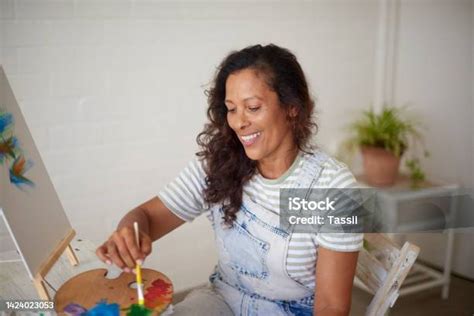 행복한 성숙한 예술가는 아트 스튜디오의 캔버스에 컬러 그림을 그리며 창의적이고 미소 짓습니다 즐거운 스트레스 해소 미술 치료 및 취미를 연습 할 수있는 자유 시간을 즐기는