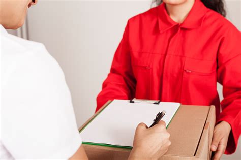 흰색 배경 위에 고립 된 소포 상자와 함께 빨간 모자에 서 행복 한 젊은 배달 남자의 이미지 가정 생활에 대한 스톡 사진 및