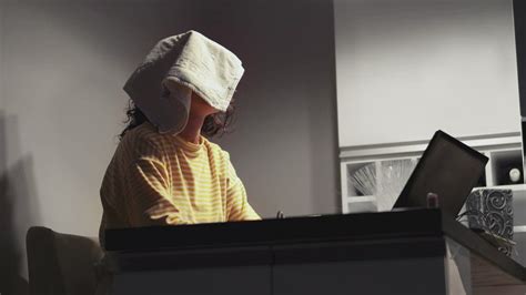 Shy Female Hacker Using Keyboard Typing Bad Data Into Computer Online System Covering Her Head