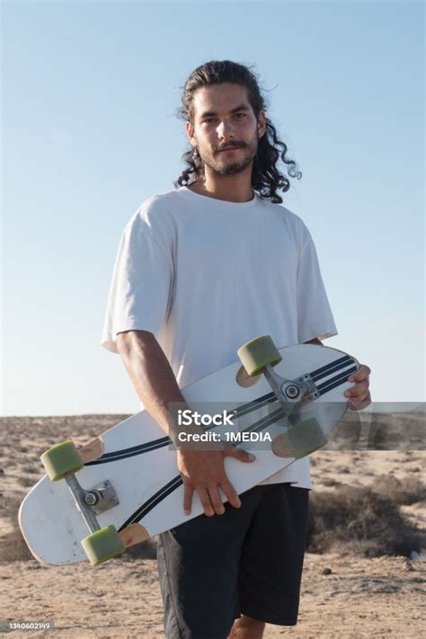 그의 스케이트 보드를 들고 야외에서 서 젊은 성인 스케이터 초상화 검정 머리에 대한 스톡 사진 및 기타 이미지 검정 머리 긴 머리 길거리 스타일 Istock