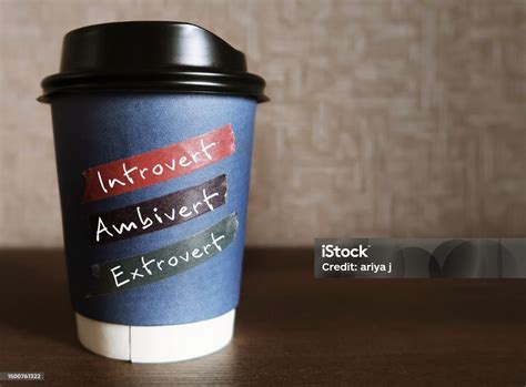 손으로 쓴 텍스트가 있는 복사 공간 배경에 종이 커피 컵 내향적인 외향적인 양가성 내향적인 사람들은 사교 후에 지치는 경향이 있는 반면 외향적인 사람들은 활력을 느끼는