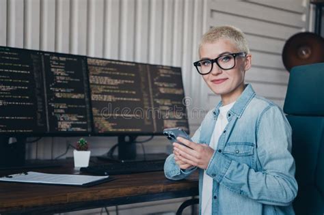 Young Female Programmer In Casual Attire Coding In A Modern Workspace