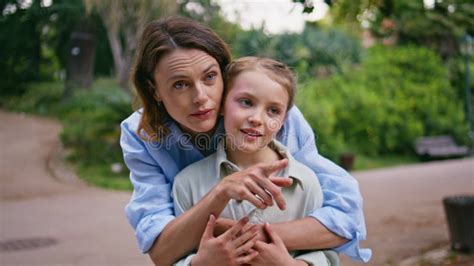 Tender Mother Daughter Embracing At Park Looking Closeup Woman