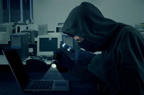 Premium Photo Computer Hacker Holding Illuminated Flash Light And Magnifying Glass Over Laptop