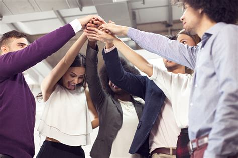 Multiethnic Work Team Raises Its Hands As A Sign Of Celebration Stock