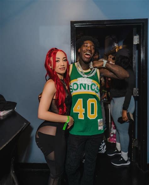 Two People Standing Next To Each Other In Front Of A Mirror With One