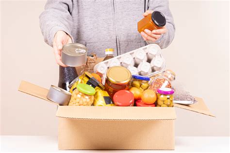 흰색 책상에 식료품으로 가득 찬 식품 기부 상자를 가진 자원 봉사자 손 음식 기부에 대한 스톡 사진 및 기타 이미지 음식 기부 Charitable Foundation
