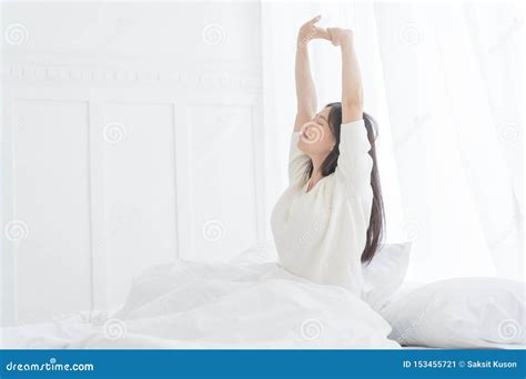 Young Asian Woman In The Morning She Stretching In Her Bed In The