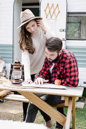 모자를 쓴 남자와 여자가 트레일러 근처 테이블에서 관광지도를 본다 2명에 대한 스톡 사진 및 기타 이미지 2명 가족 관광