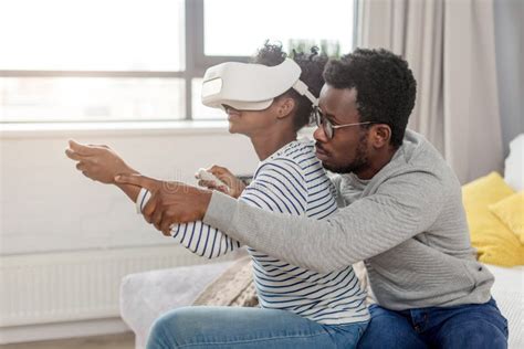 African Couple Play Video Games Wearing Virtual Reality Glasses At Home