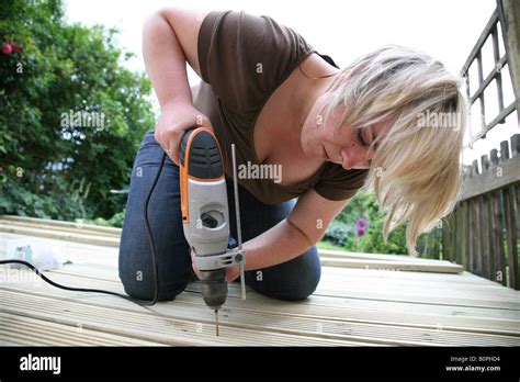 Female Laying Decking In The Garden And Using The Drill To Screw In The Screws Stock Photo Alamy