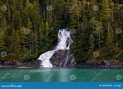 Beautiful Flowing Waterfall Into The Ocean In Endicott Arm Alaska