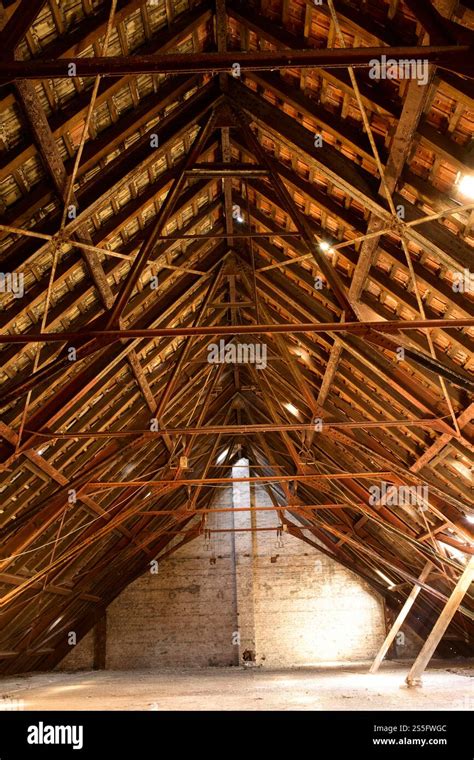 Wooden Beams Form A Complex Triangular Structure In The Attic Of A