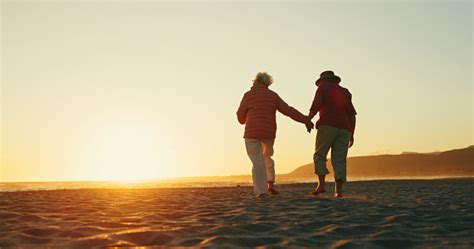 일몰 여름 휴가 은퇴 및 행복을 위해 해변에서 노파와 손을 잡고 등받이 친구 여행 모험 및 모형 공간을 위한 노인과의 휴가