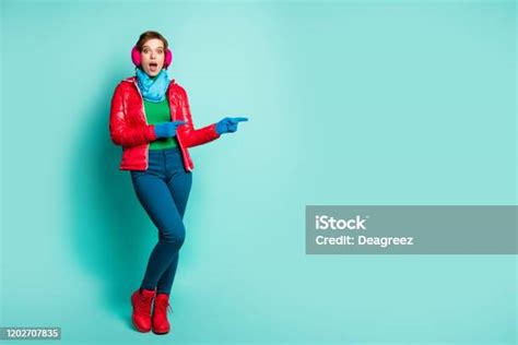 예쁜 아가씨의 전신 사진 손가락 빈 공간을 나타내는 판매 가격 블랙 프라이데이 착용 빨간 오버 코트 블루 스카프 핑크 귀 머프 바지 신발 고립 된 청록색 색상 배경