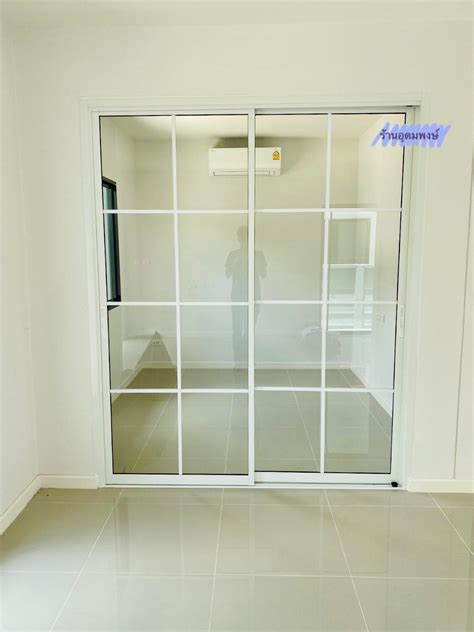 ประตูกระจกบานเลื่อน รูปแบบ แบ่ง 2 บานสลับซ้าย ขวา เสริมตาราง สวยมีสไตล์ อลูมิเนียมอบขาว กระจกใส