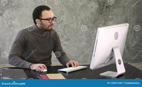 Casual Businessman Working In Office Sitting At Desk Typing On