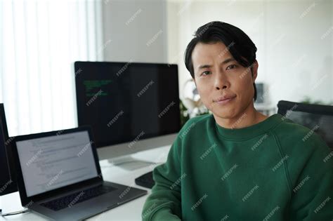 Premium Photo Portrait Of Serious Asian Software Developer Sitting At His Office Desk