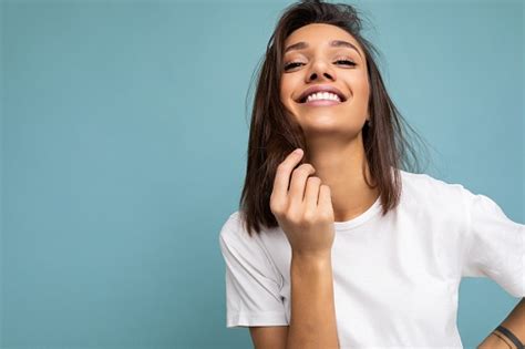 긍정적 인 행복 미소 젊은 매혹적인 매력적인 좋은 갈색 머리 여자의 초상화 사진 은 텍스트를위한 무료 공간과 파란색 배경에 고립